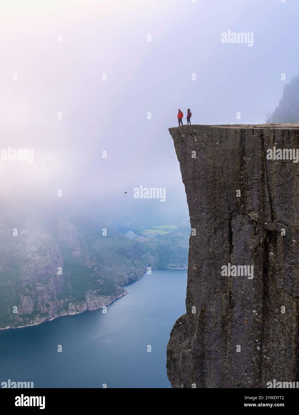 A depressed couple stands on the edge on the edge of a cliff, taking in ...