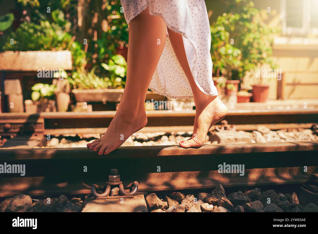 Travel, woman and walking barefoot on railway for holiday exploration ...