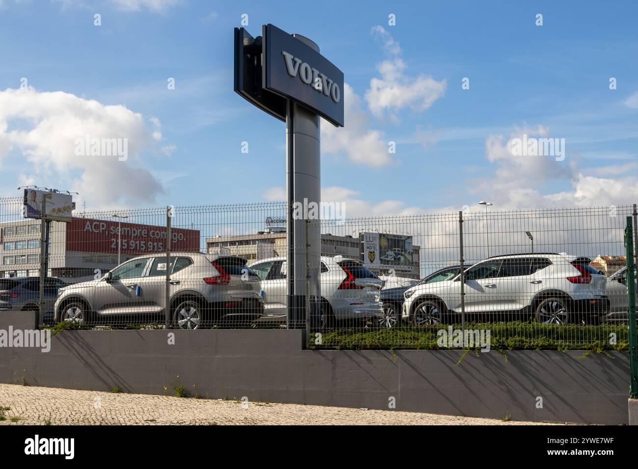 New volvo cars parked at dealership behind a fence with the volvo logo ...