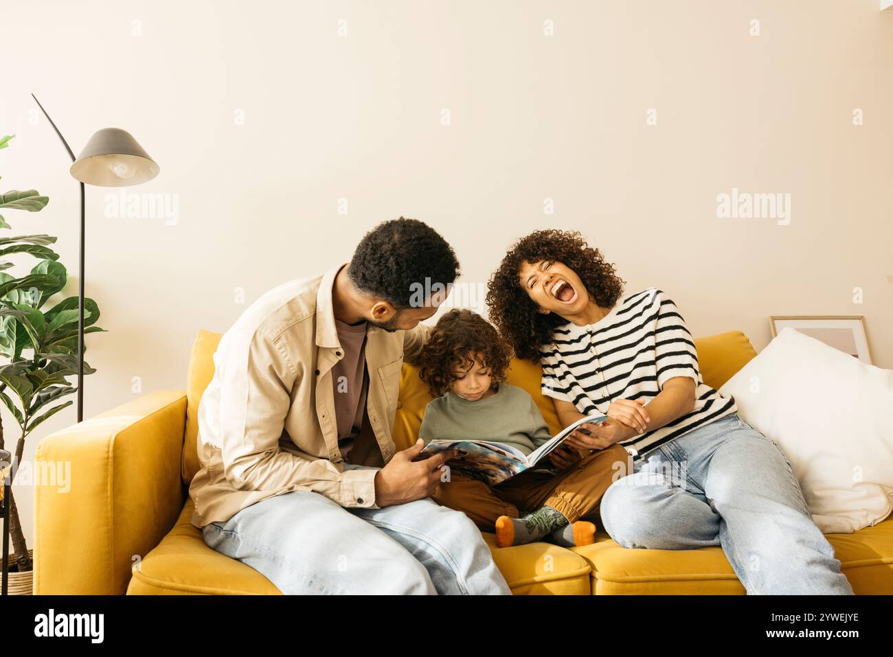 A cheerful family enjoys quality time reading a book together on a ...