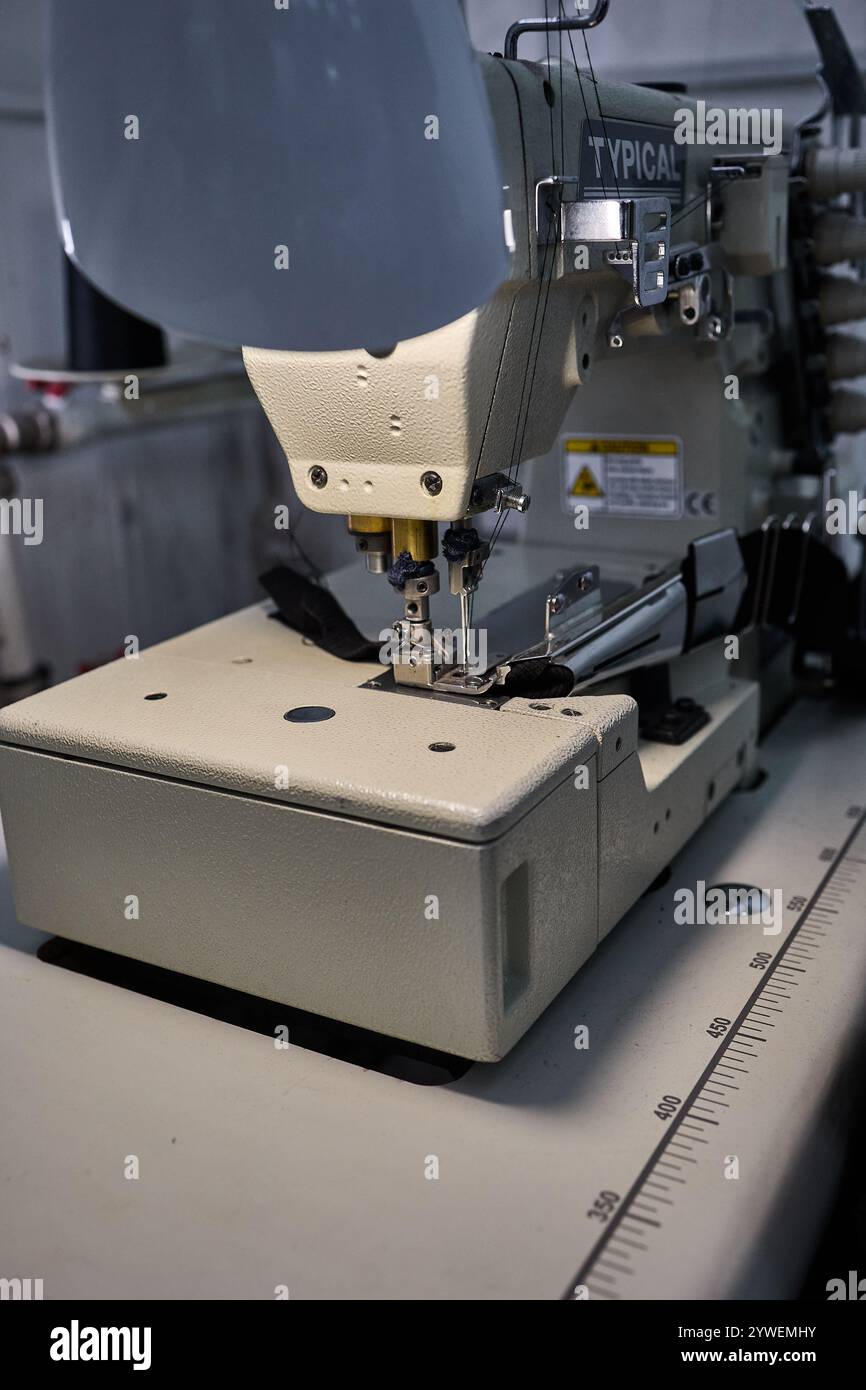 A skilled textile worker operates an industrial sewing machine ...