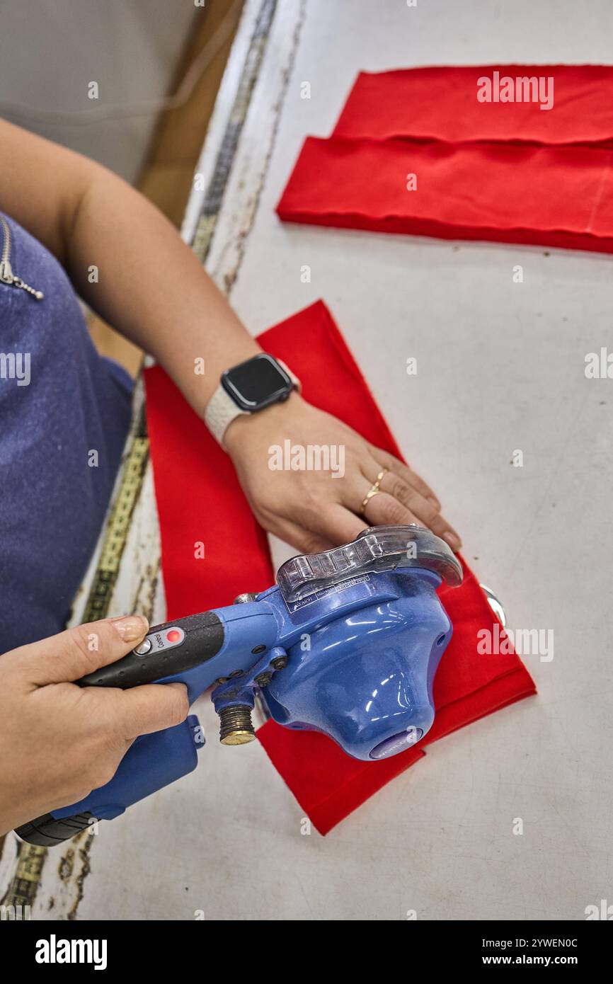This image captures the process of cutting fabric for garment ...