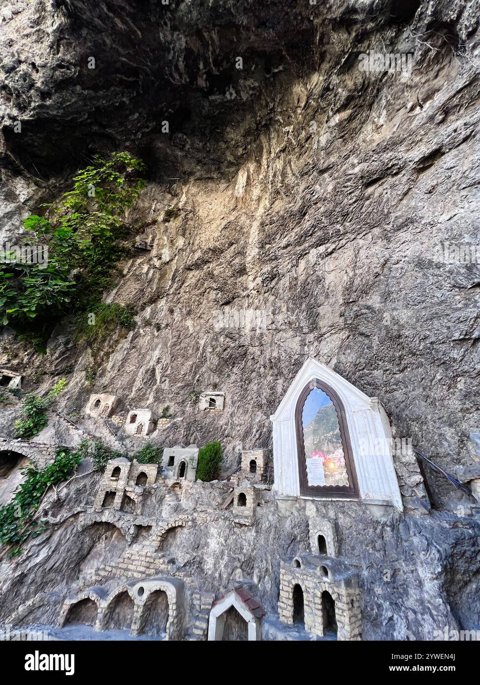 A fascinating rock wall featuring detailed miniature structures ...
