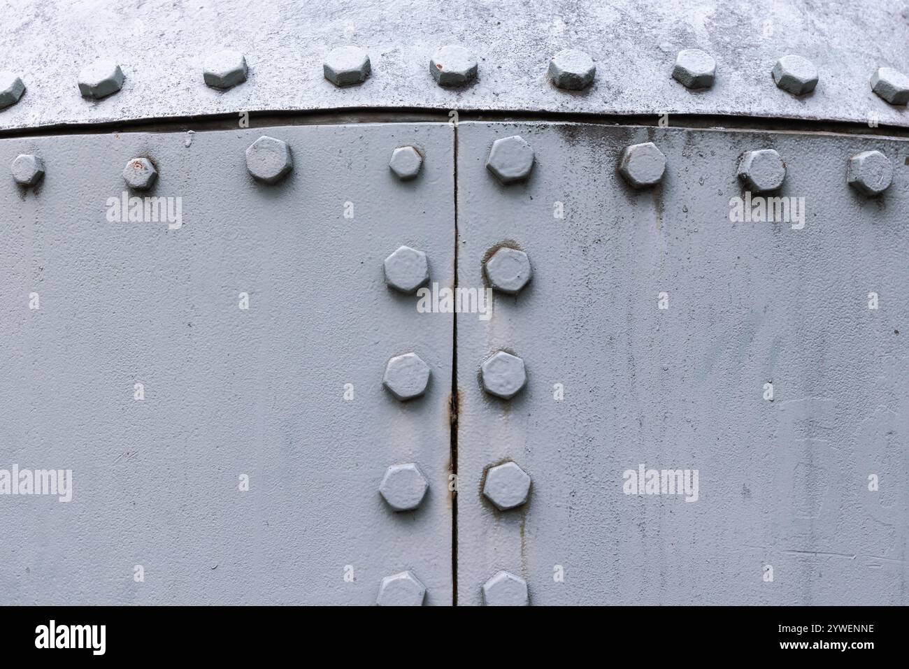 Light gray steel wall with bolts, metal parts connection, close-up ...
