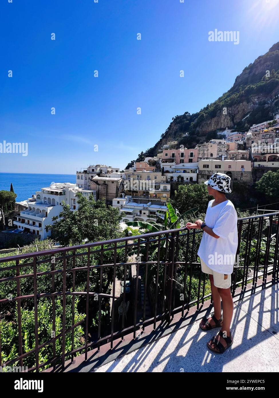 Boy in casual attire gazes at the beautiful hillside architecture of a ...