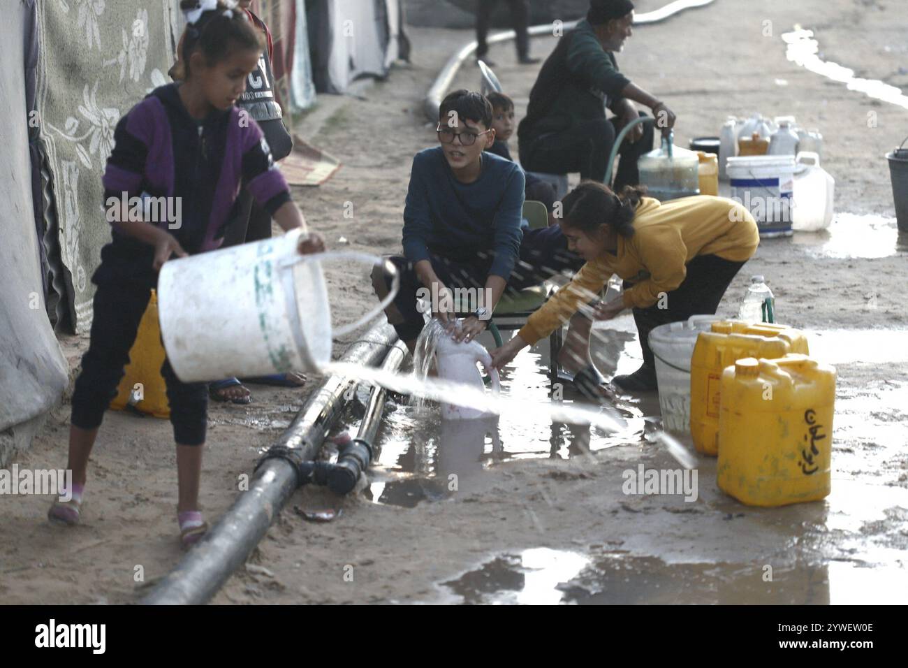 Children use the underground water line to obtain drinking water in ...