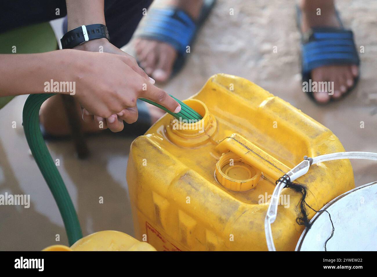 Children use the underground water line to obtain drinking water in ...