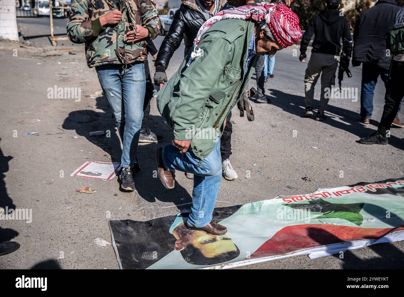 Syria. 10th Dec, 2024. Men step on the photos of former Syrian ...
