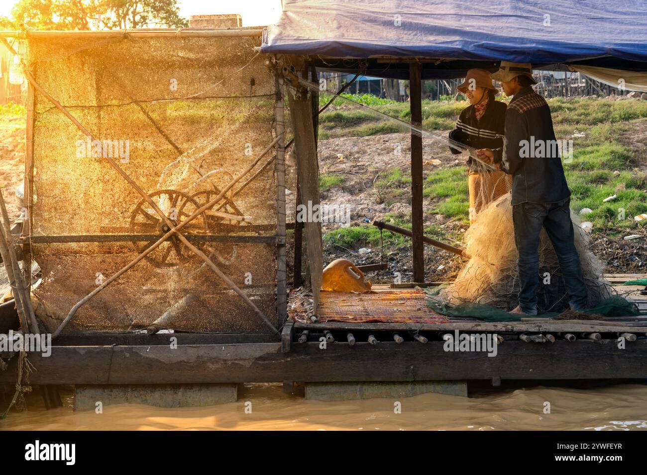Local fishermen pulling the fishing net from the river in Tonle Sap ...