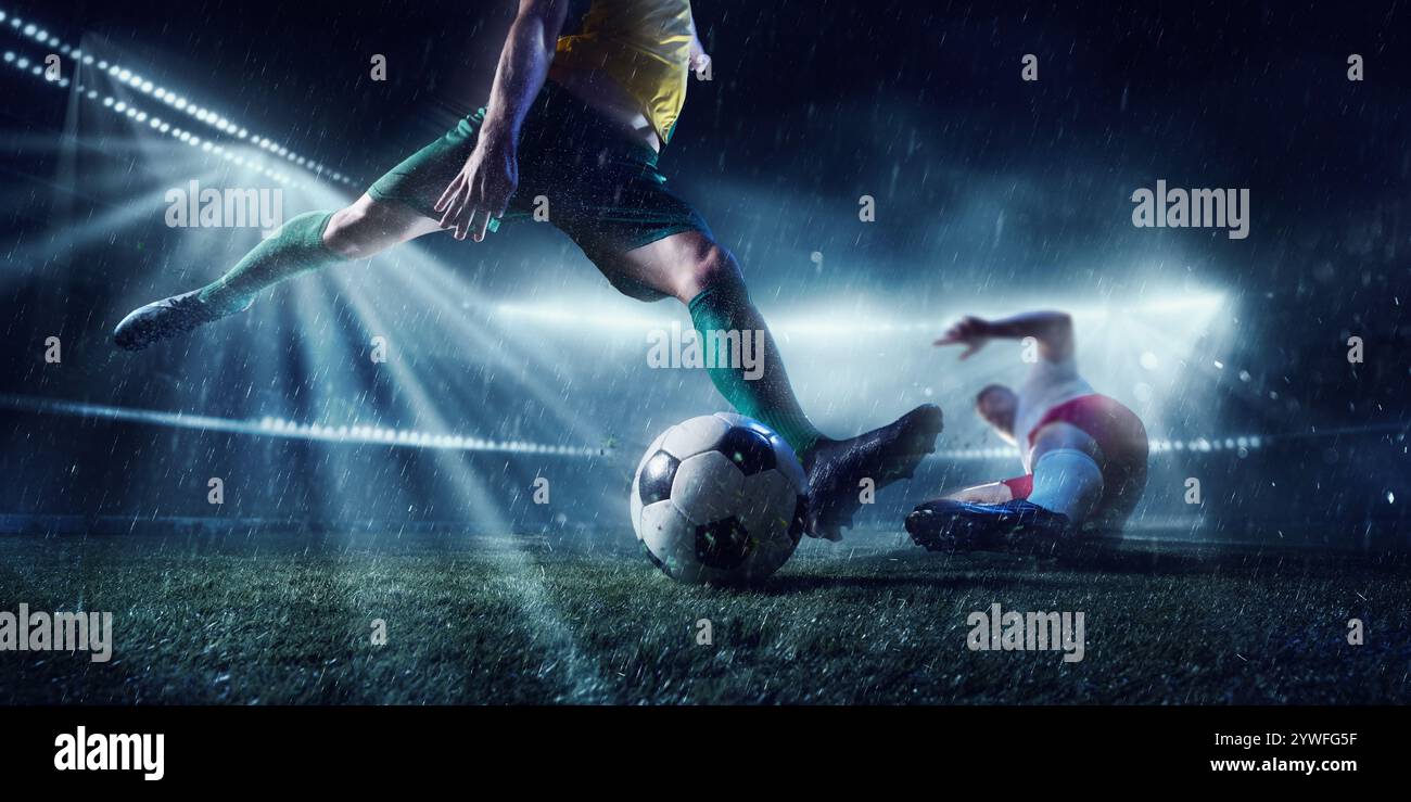 Two competitive football players in motion try to keep defense in wet ...