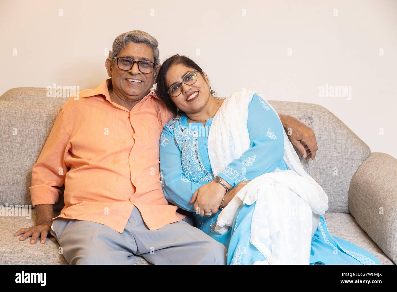 Happy Indian senior couple enjoying time together while sitting on sofa ...