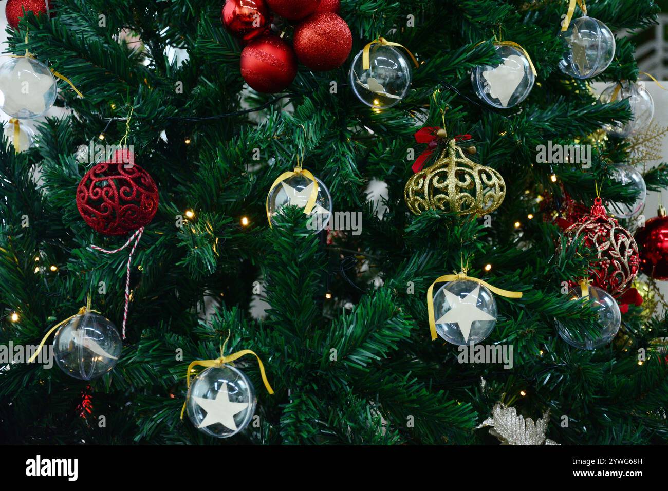 Christmas balls of various types and colors on a green tree with stars ...
