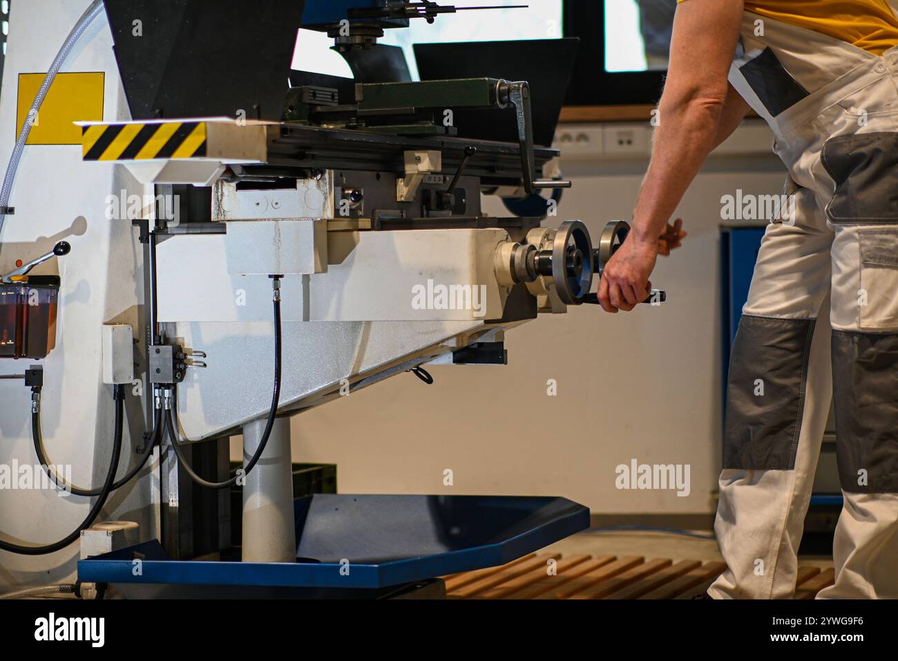 Factory worker operating a milling machine, demonstrating workplace ...