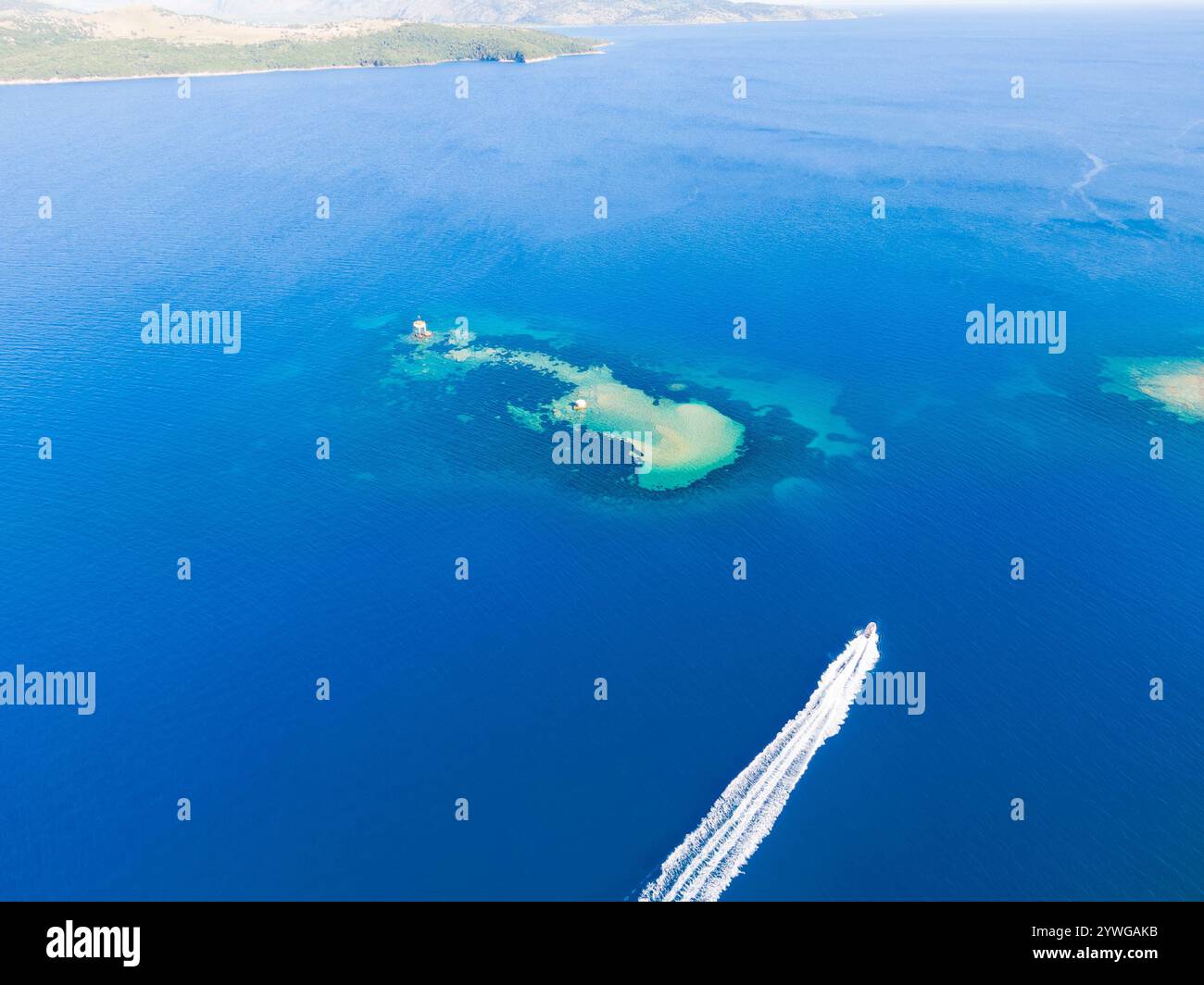 Aerial view of a boat navigating azure waters near a small island Stock ...