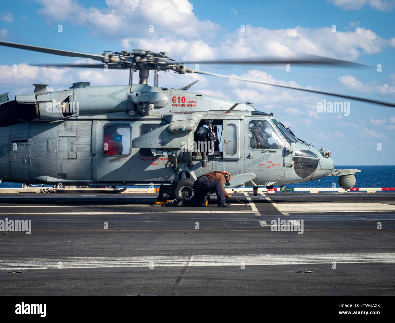 241210-N-AC395-2650 PHILIPPINE SEA (Dec. 10, 2024) – A Sailor chains down an MH-60S Sea Hawk ...