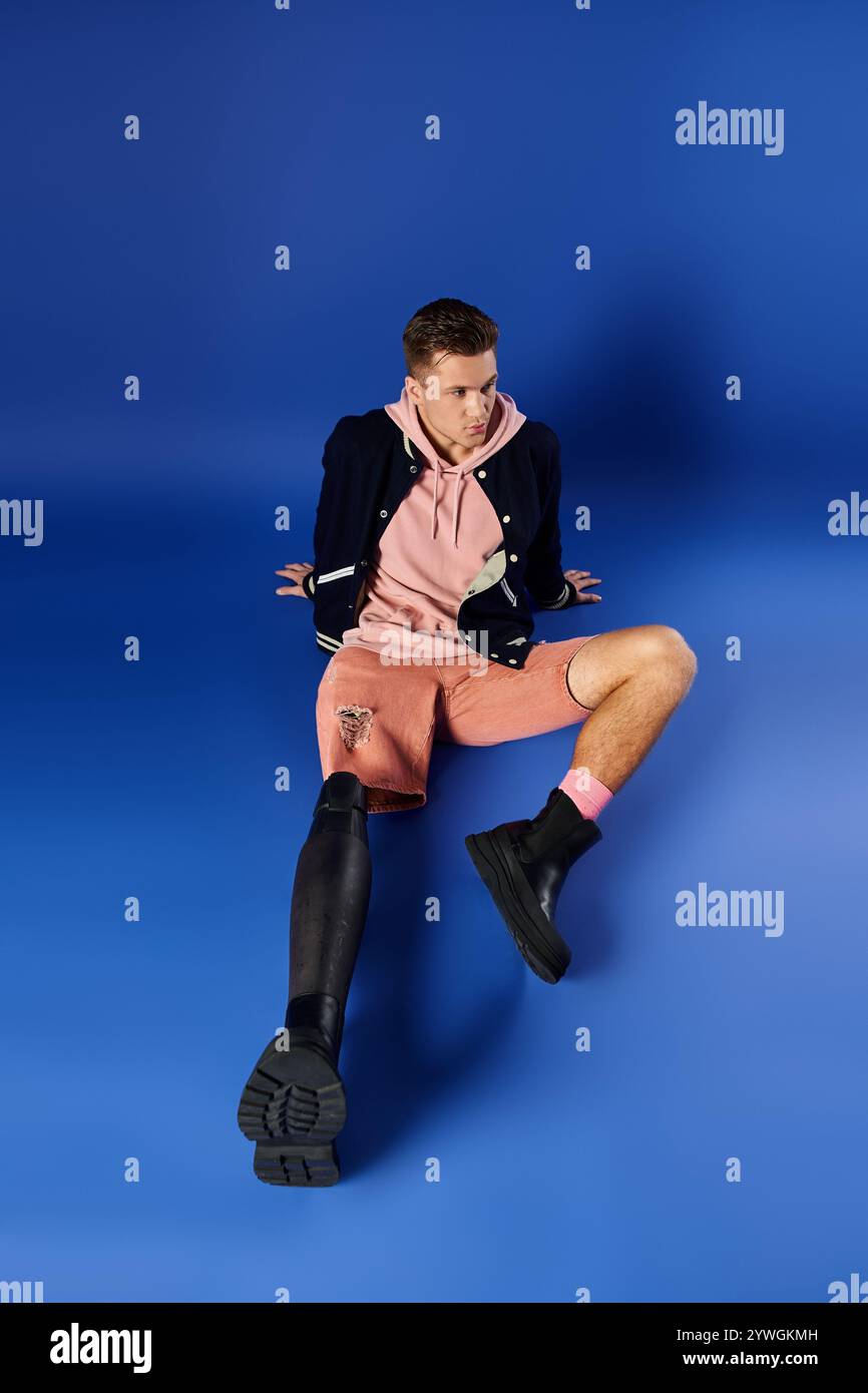 A young man with a prosthetic leg sits confidently on the ground ...
