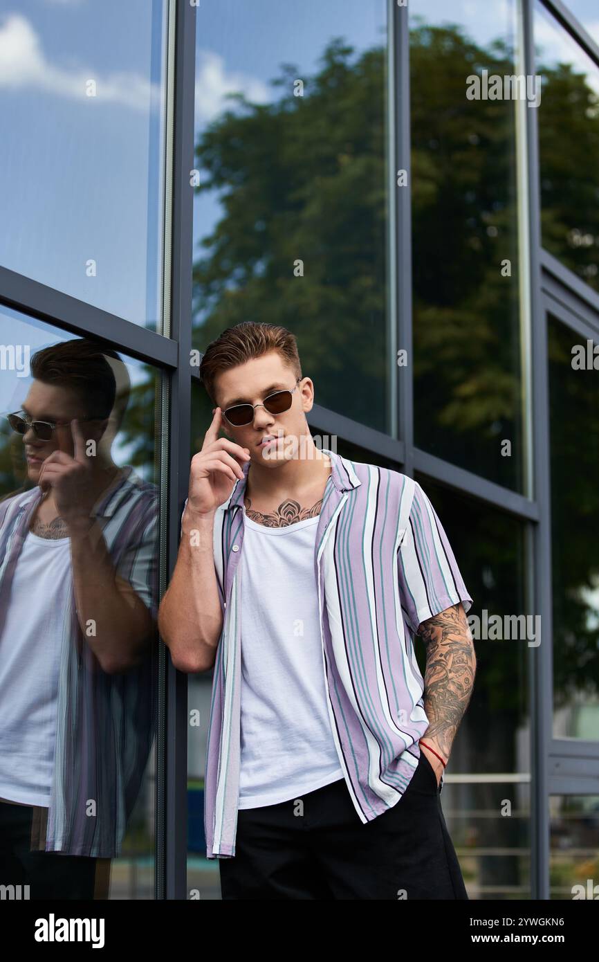 A young man stands confidently outside a modern building Stock Photo ...