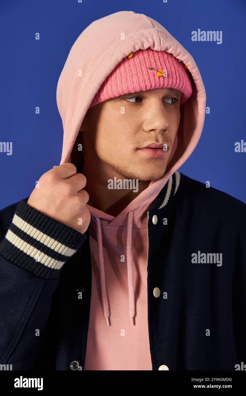 Young man poses fashionably in a striking outfit with a playful ...