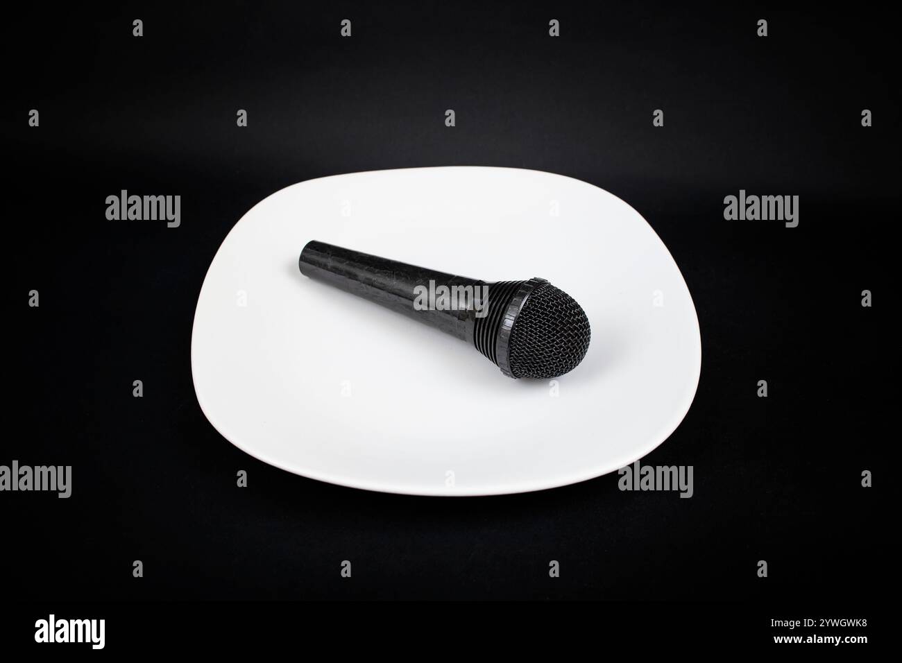 black microphone on white plate, minimal backdrop Stock Photo - Alamy