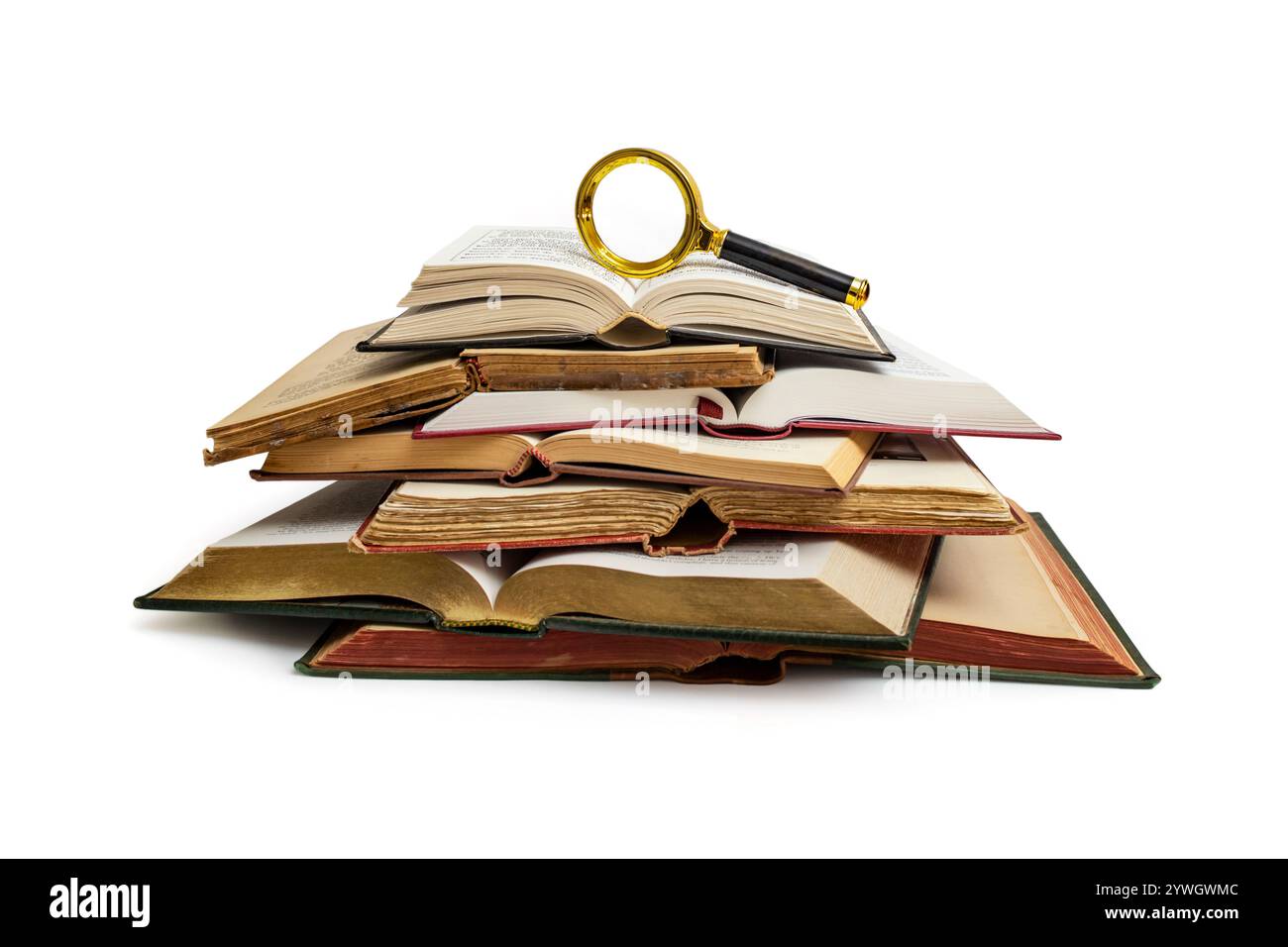 Vintage hard cover books opened and stacked with a magnifying glass on ...