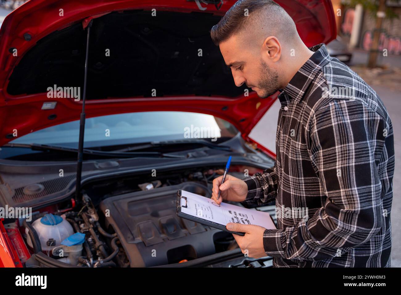 Insurance agent taking notes on clipboard while inspecting a damaged ...