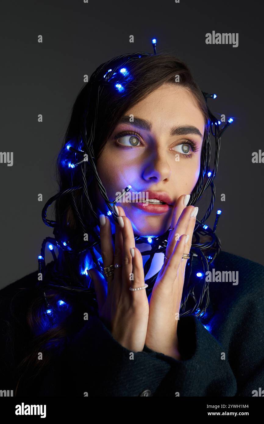 A young woman glows in blue lights, highlighting her expressive ...