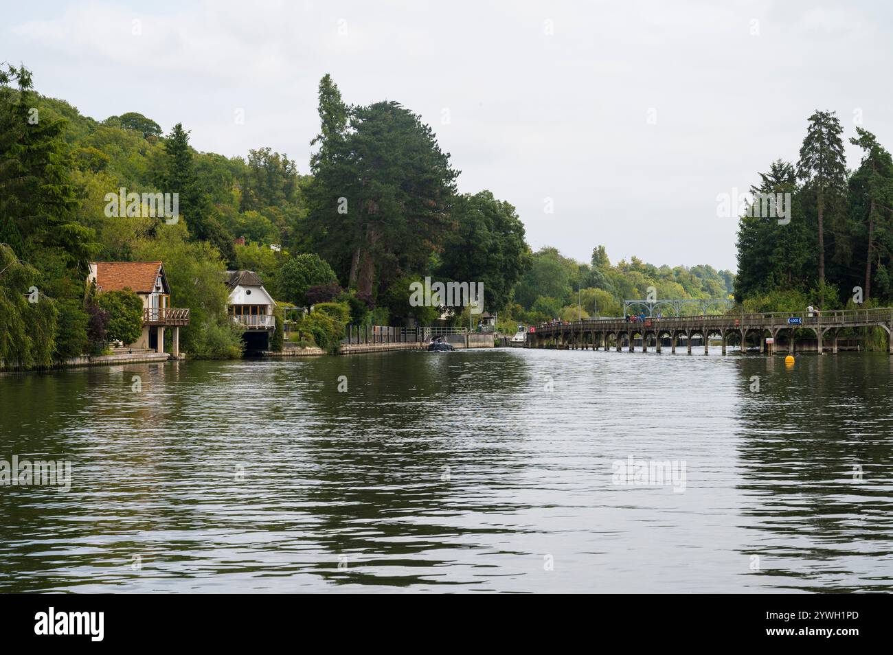 People crossing the wooden footbridge at Marsh Lock on the River Thames ...