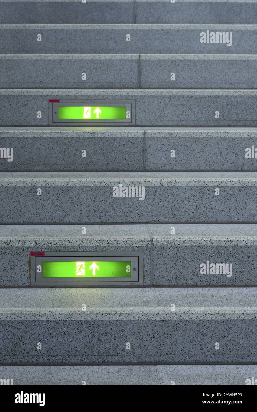 Public staircase with green illuminated emergency exit signs, Germany ...