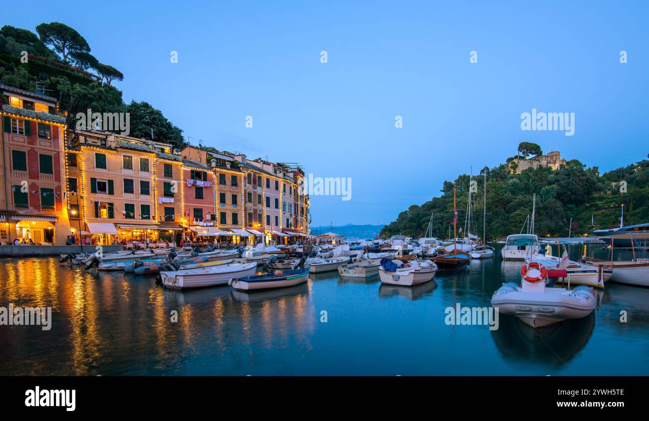Charming port of Portofino at dusk with boats and waterfront buildings ...