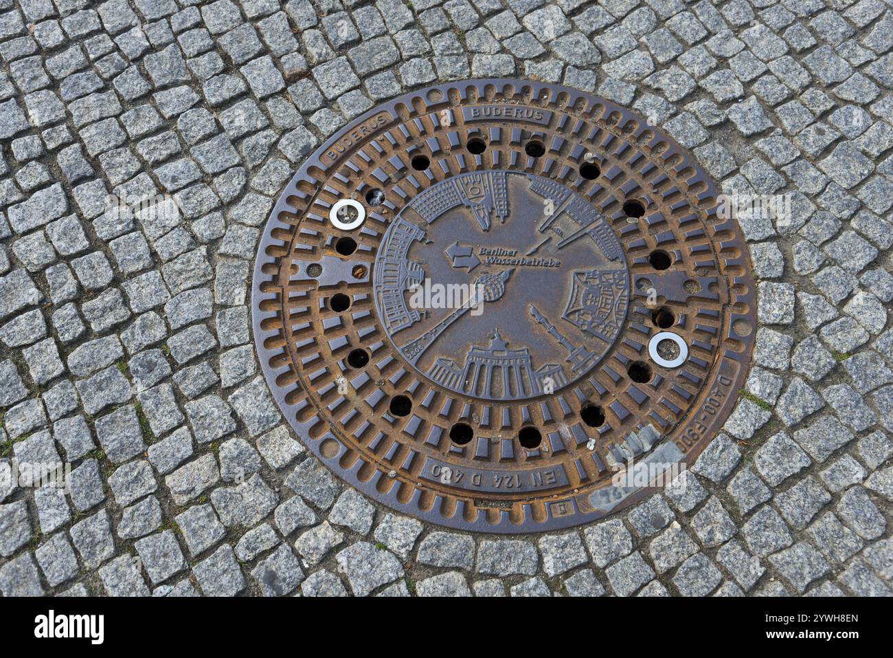 Artfully designed manhole cover on paved street in Berlin, gully cover ...