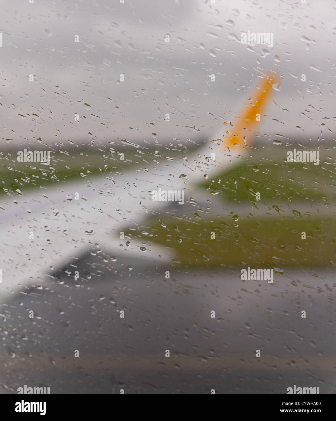 This photo captures a rainy day view from an airplane window. Water ...