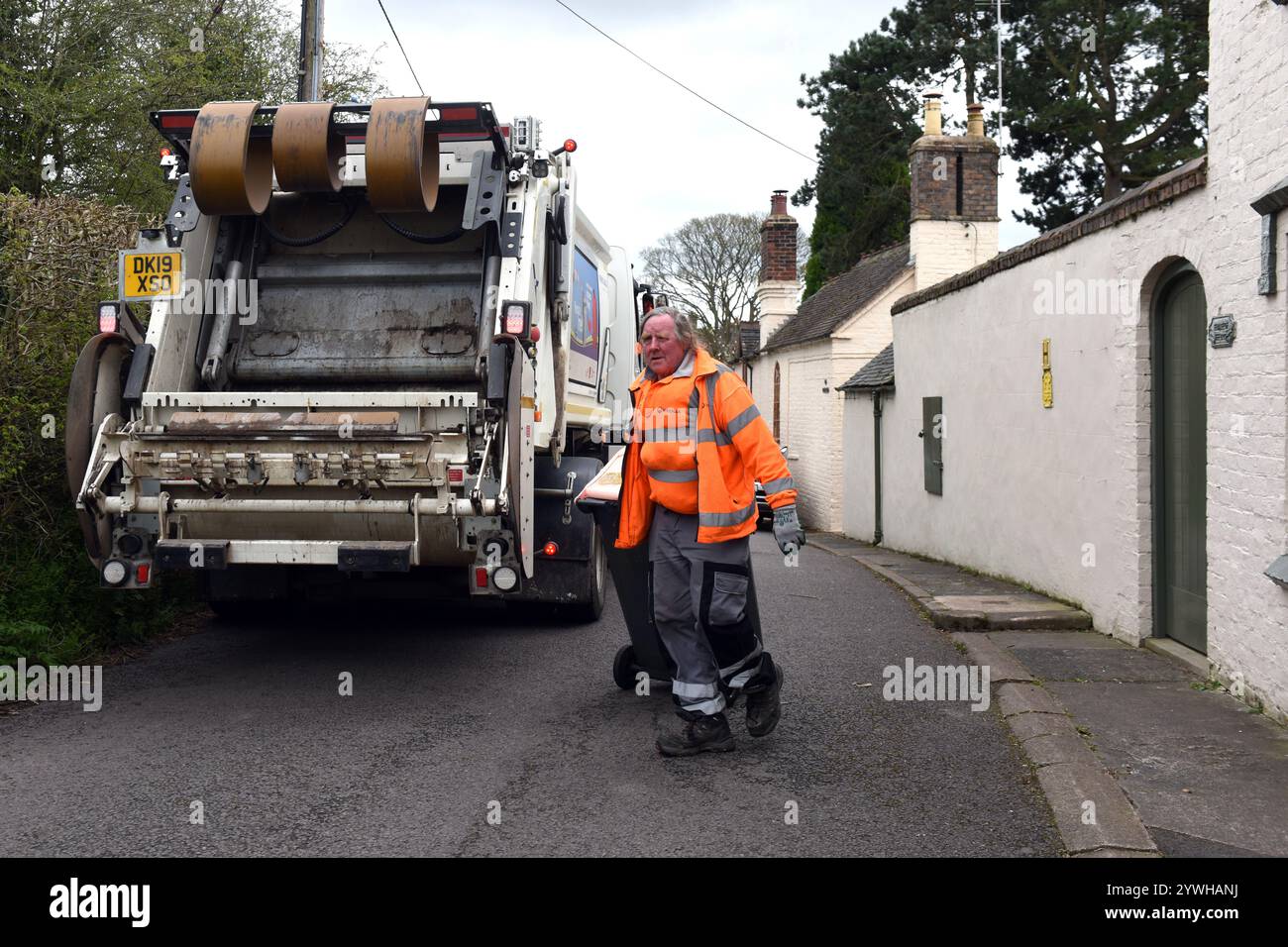 Council bin man refuse collecting household waste wheelie bin in ...