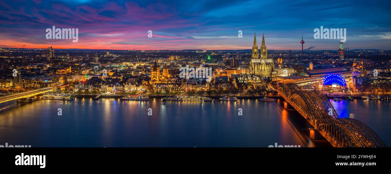 Vibrant skyline of Cologne illuminated at dusk with famous landmarks ...