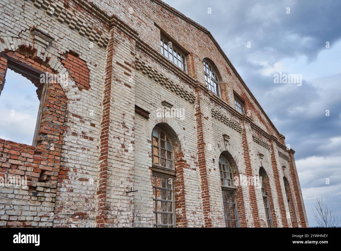 Abandoned destroyed brick building built in 1912. Wall with windows of ...