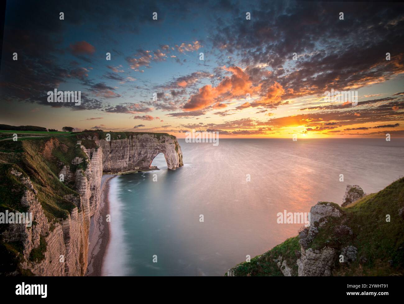 Stunning sunset over the dramatic cliffs and arch at Etretat, France during evening hours Stock ...