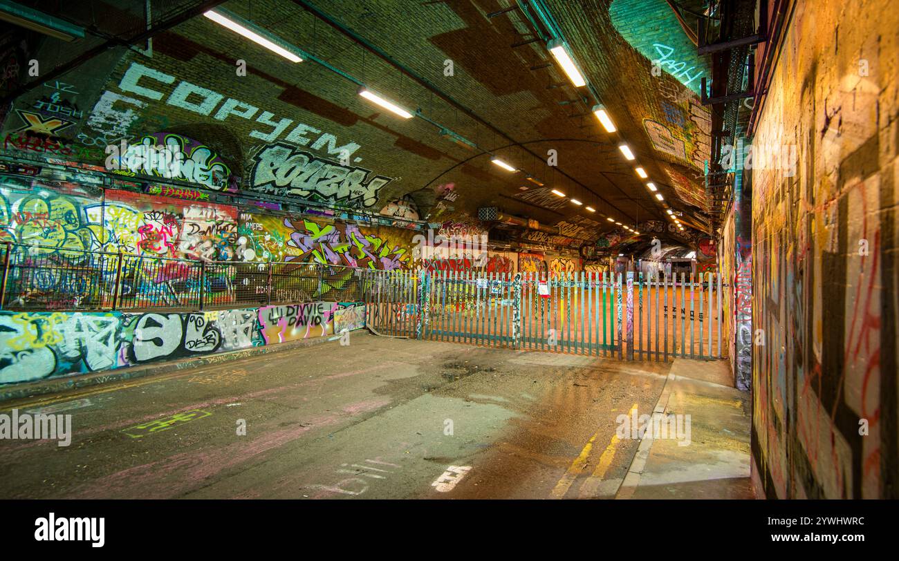 Urban tunnel covered in colorful graffiti with vibrant street art and ...