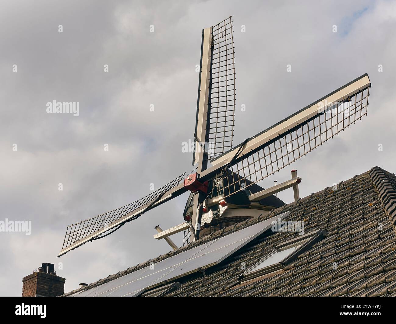A Dutch windmill combined with solar panels on a tiled roof ...