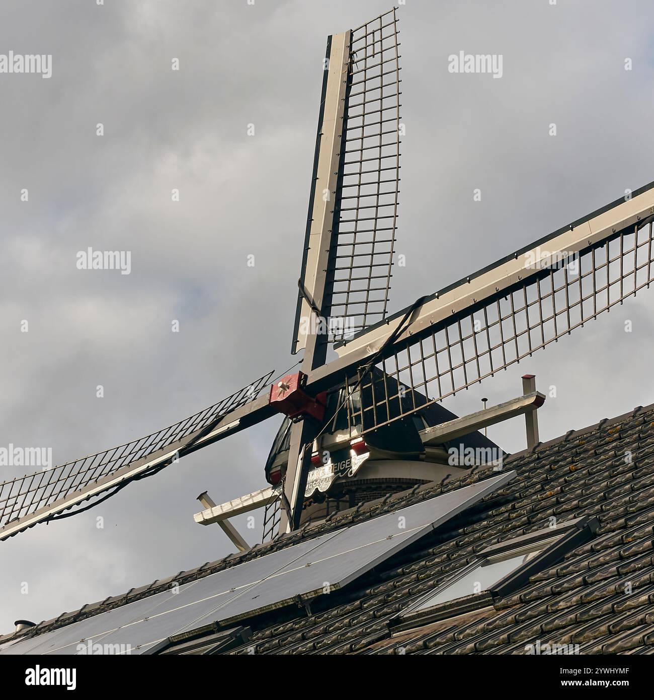 A Dutch windmill combined with solar panels on a tiled roof ...