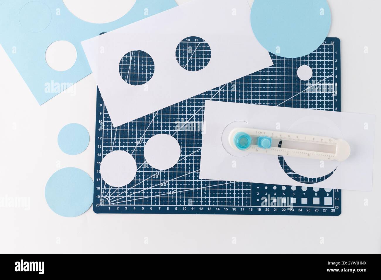 white paper with circular cutouts, and a circle cutter tool. There is a ...