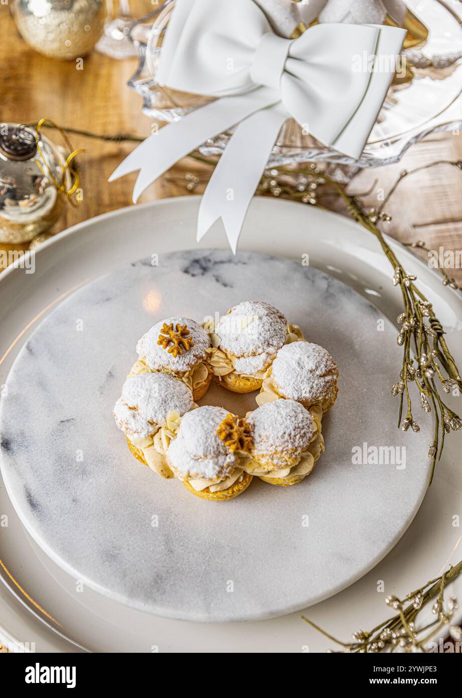 Cream puffs with praline cream filling and icing sugar on Christmas ...