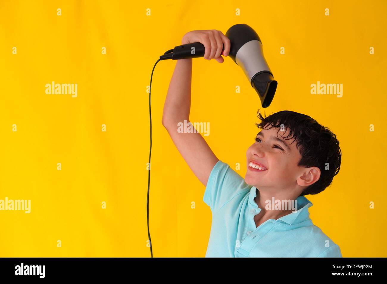 preteen boy drying his hair with a hair dryer Stock Photo - Alamy
