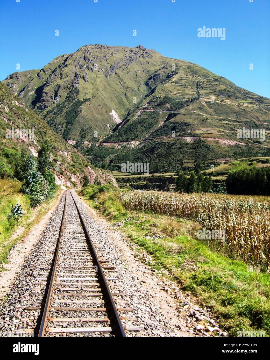 View along long straight railway line in Andean Plateau towards hills ...
