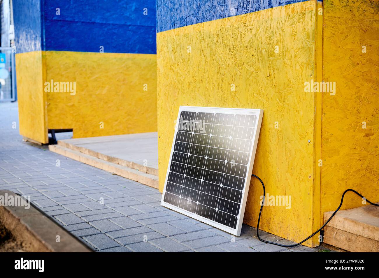 Solar panel against vibrant wall painted in blue and yellow colors of ...