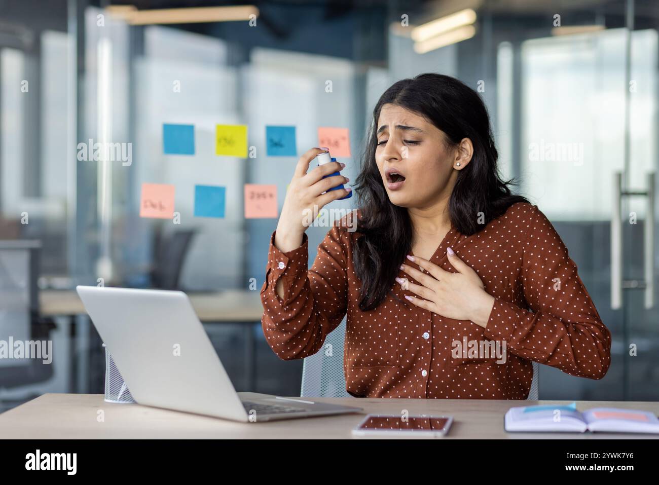 Businesswoman experiencing breathing difficulty in an office using an ...
