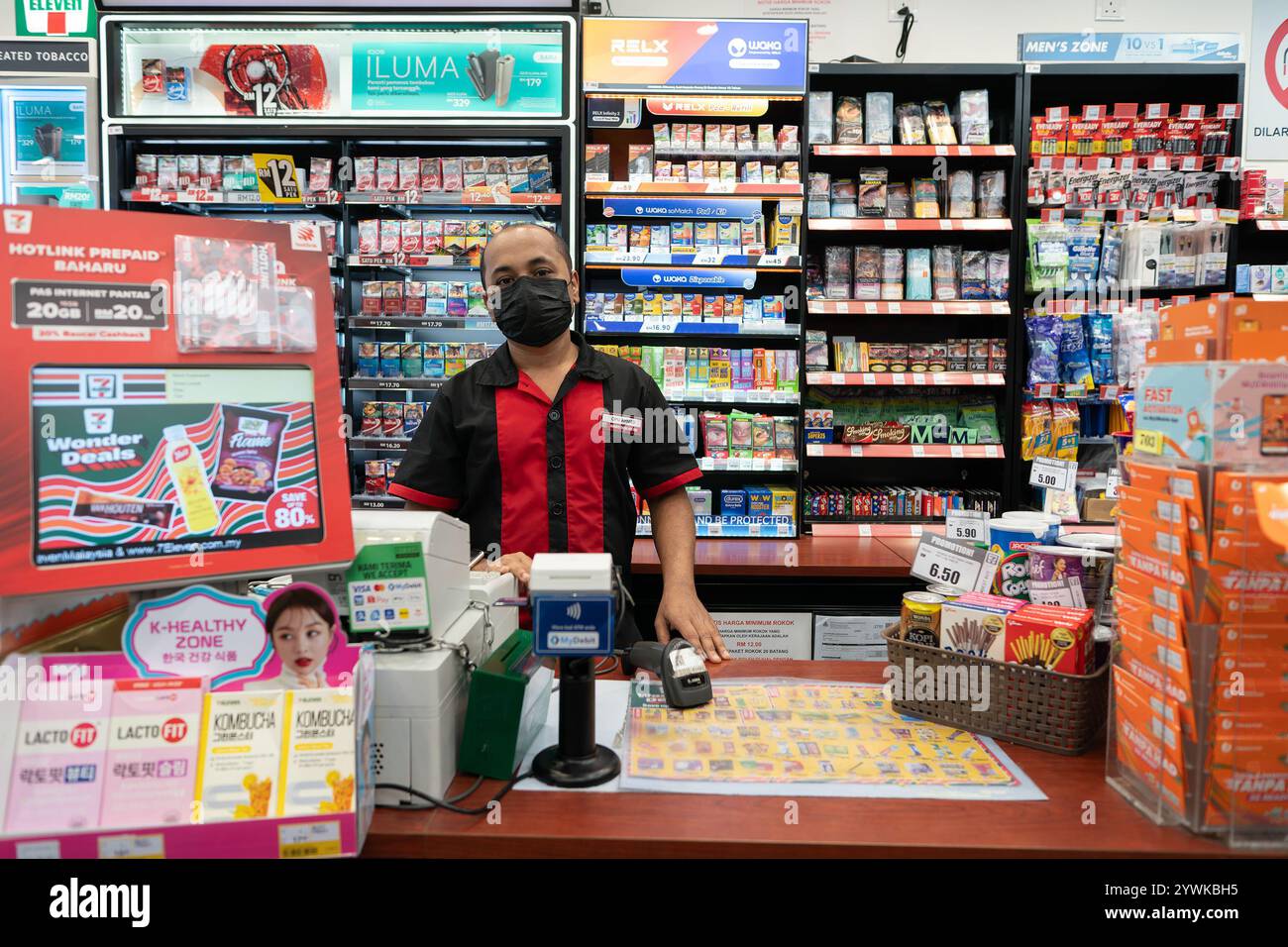 KUALA LUMPUR, MALAYSIA - DECEMBER 01, 2023: a cashier poses for a photo ...