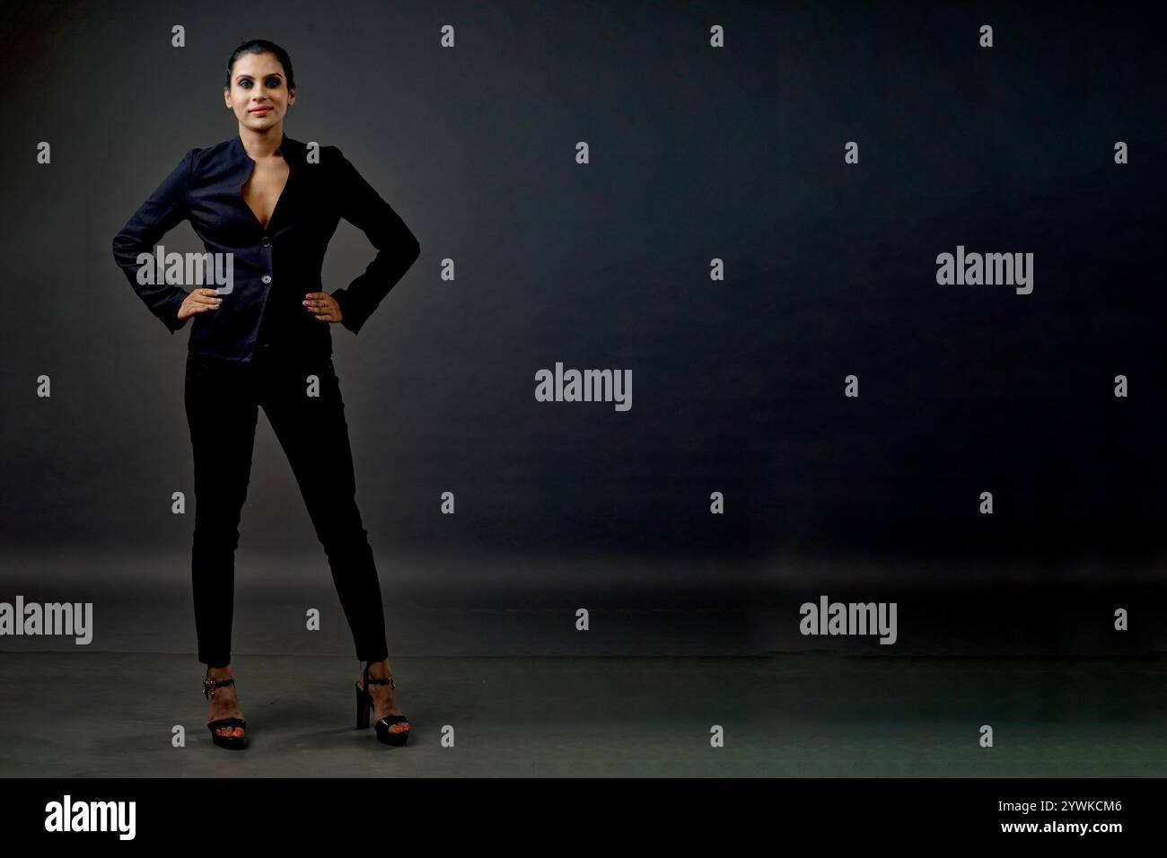 A stunning solo image of a tall female model in a classic black suit ...