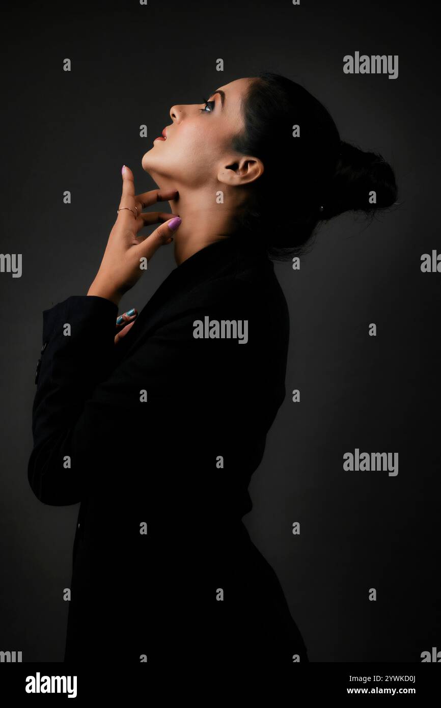 A stunning solo image of a tall female model in a classic black suit ...