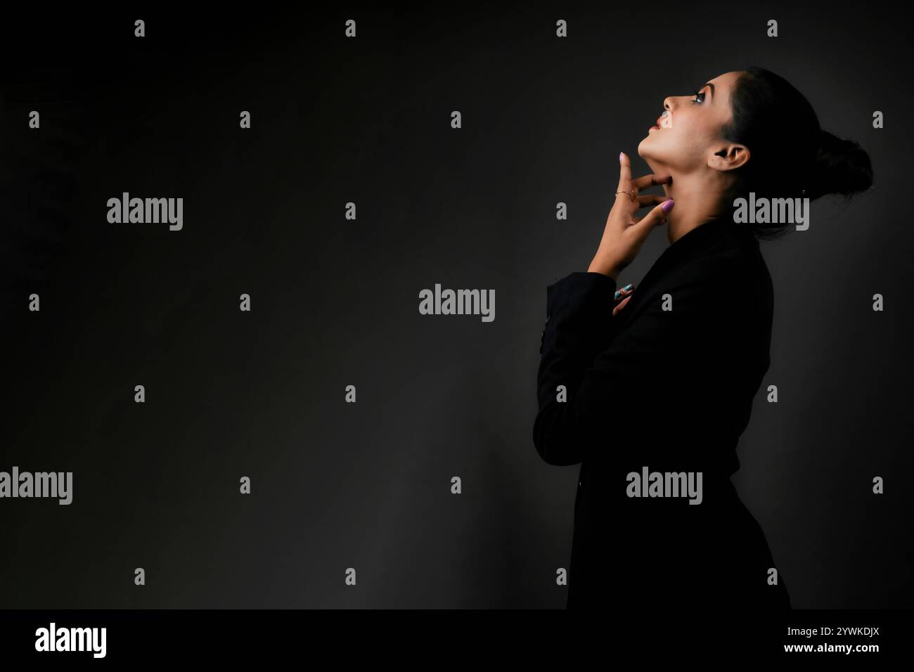 A stunning solo image of a tall female model in a classic black suit ...