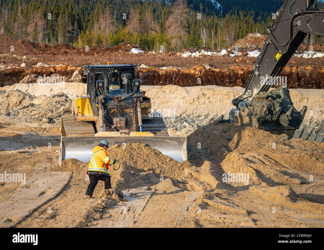 A foreman moves through the operating area of a bulldozer and an ...
