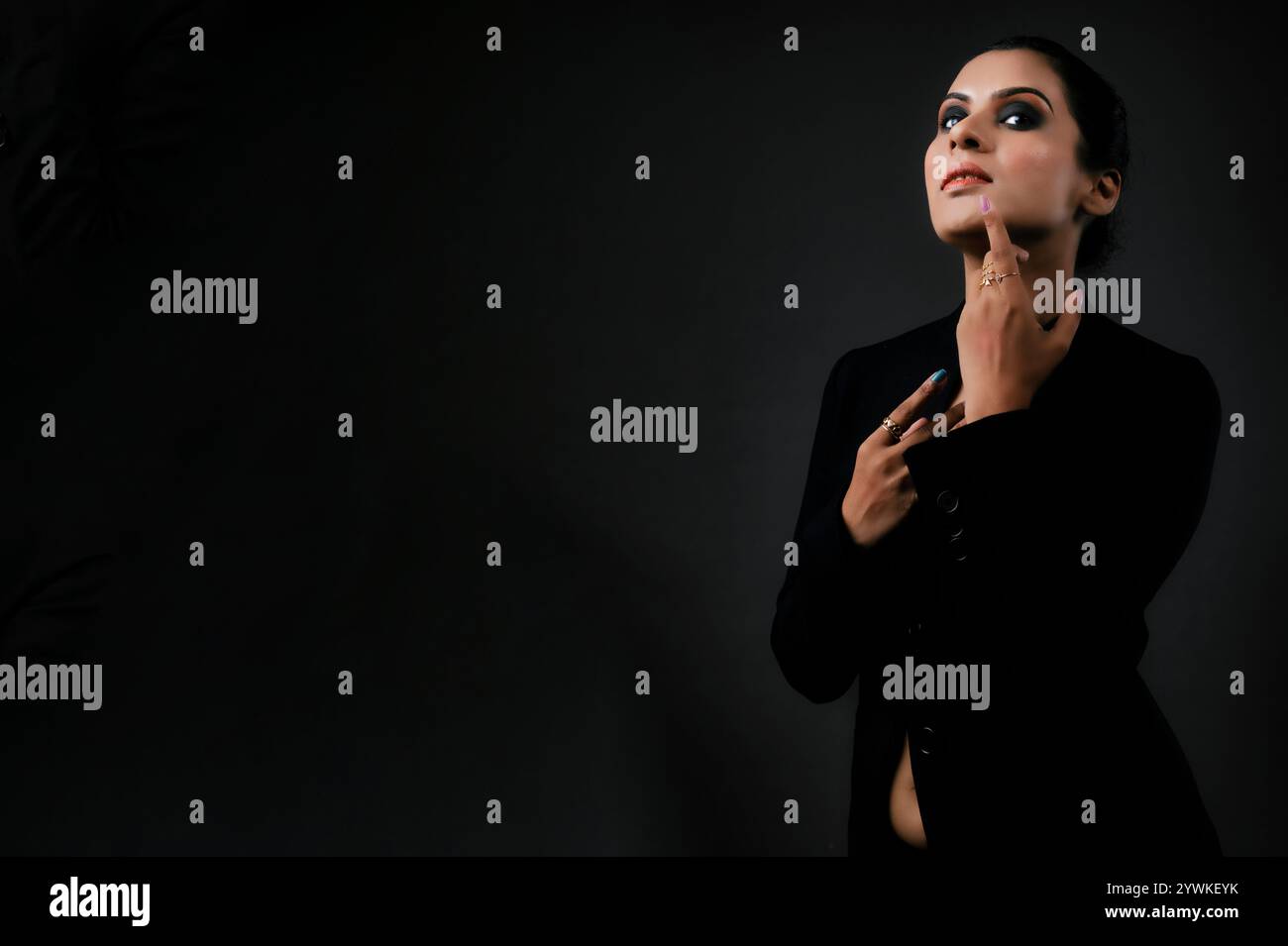 A stunning solo image of a tall female model in a classic black suit ...